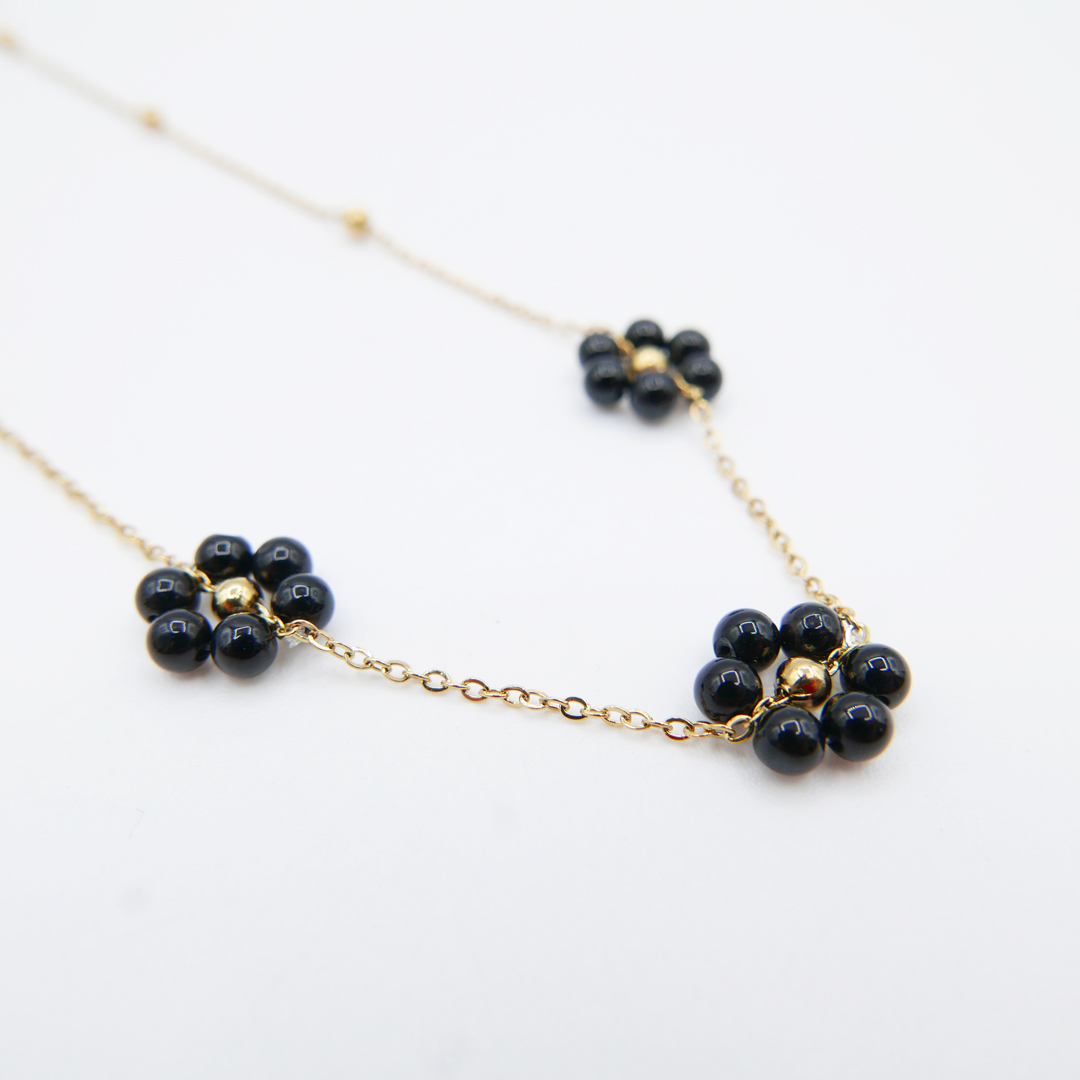 Collier en acier doré à fine chaine perlée et fleurs en agate noire