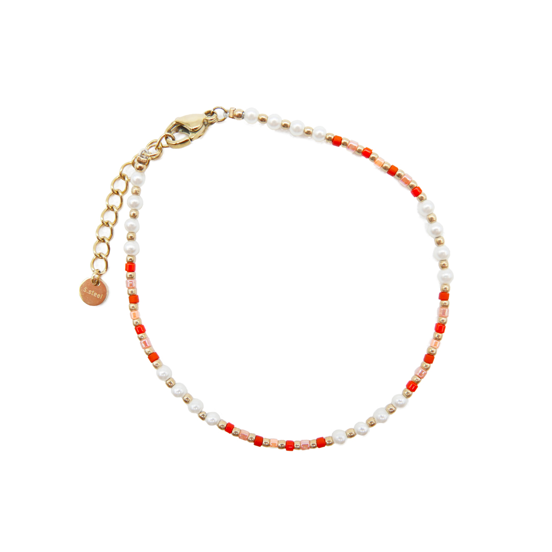 Bracelet fin en acier doré orné de petites perles corail et nacrées
