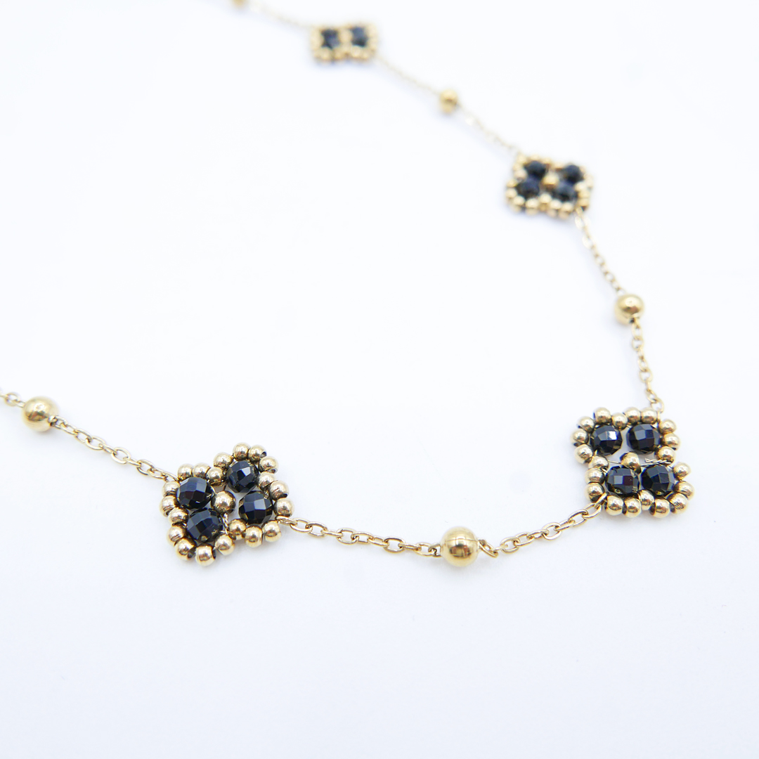 Collier en acier doré décoré de trèfles noirs